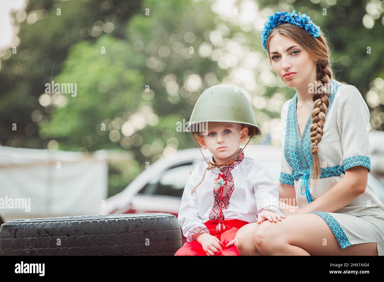 Young ukrainian woman sits with child boy in traditional national dress ...