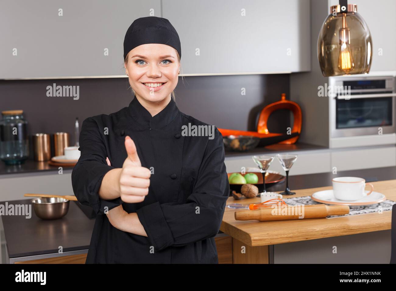 Happy female chef in black uniform Stock Photo - Alamy