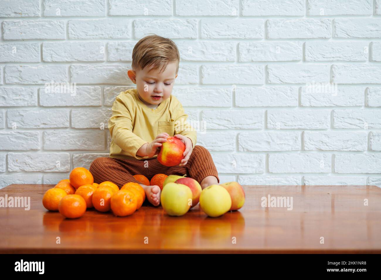 Cute smiling kid eating one fresh juicy red apple. Healthy fruits for ...