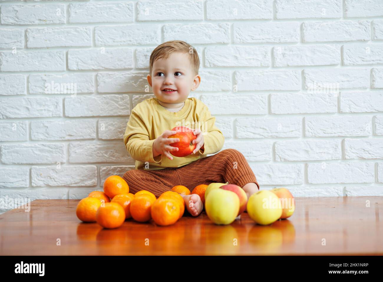 Cute smiling kid eating one fresh juicy red apple. Healthy fruits for ...