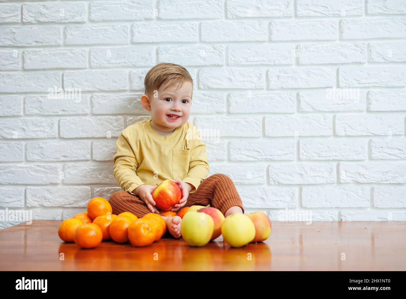 Cute smiling kid eating one fresh juicy red apple. Healthy fruits for ...