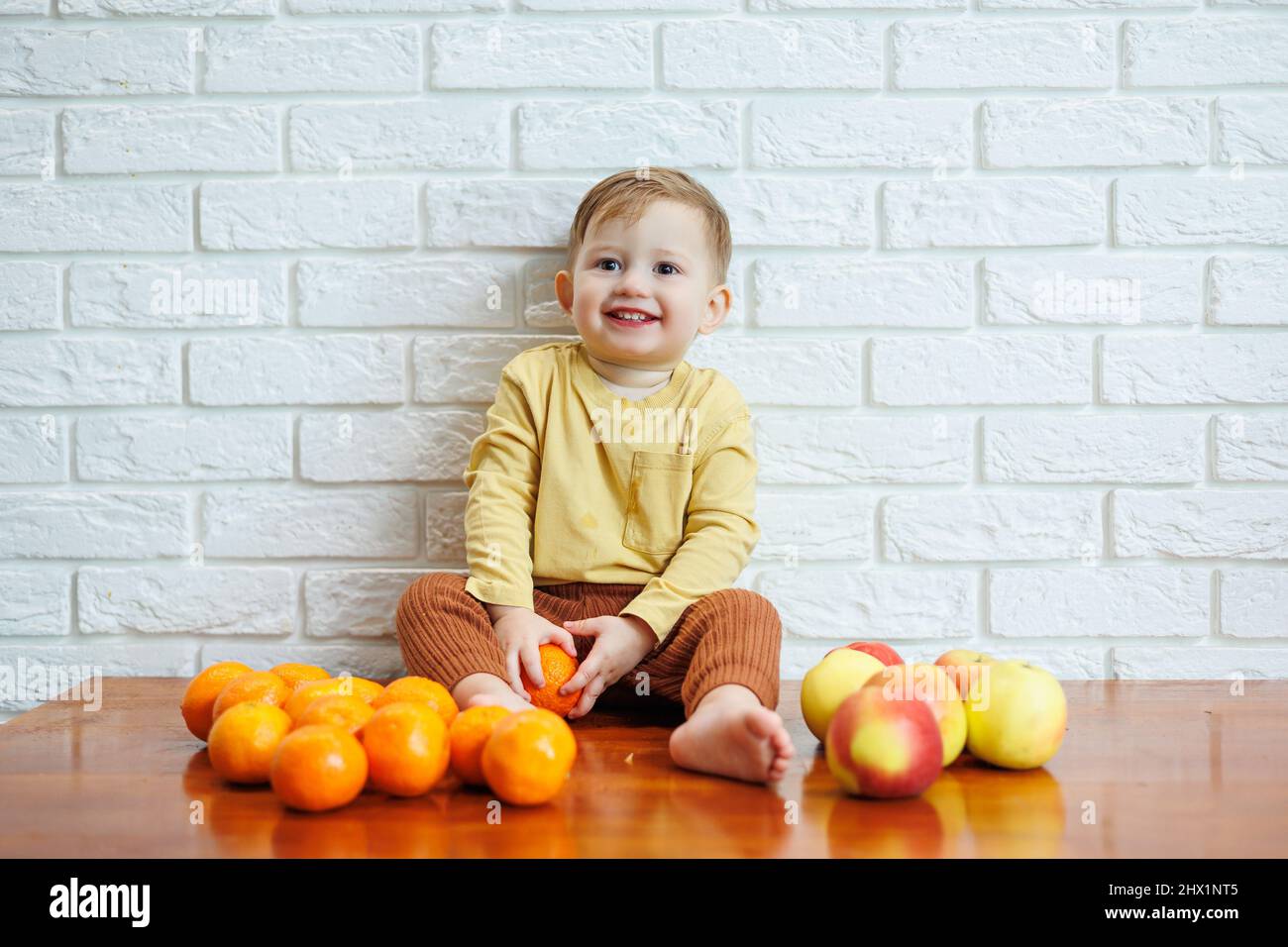 Smiling child eats one fresh juicy red apple. Healthy fruits for young ...