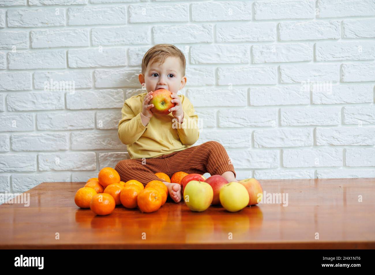 Cute smiling kid eating one fresh juicy red apple. Healthy fruits for ...