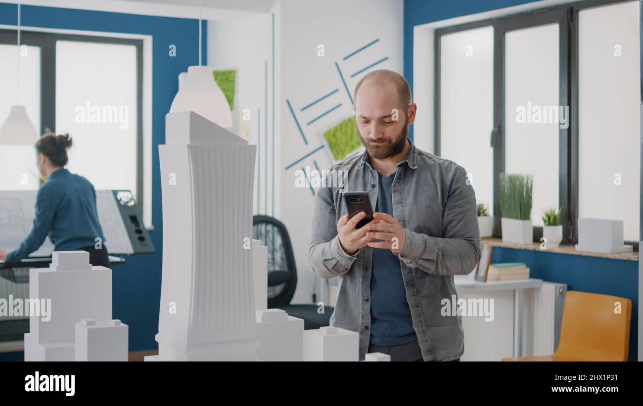 Man contractor using mobile phone to design building model for ...
