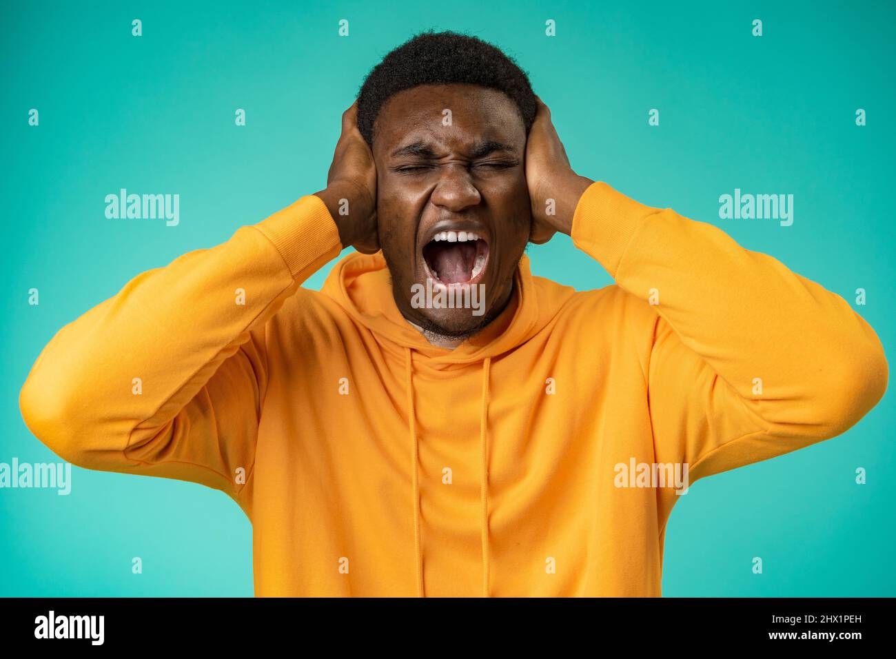 Emotional screaming young african man standing isolated over mint ...
