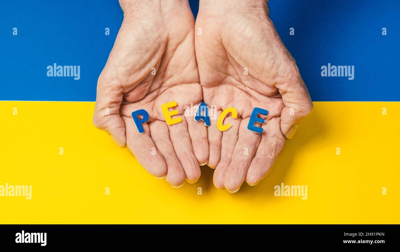 man holding a peace inscription in the colors of the ukrainian flag ...