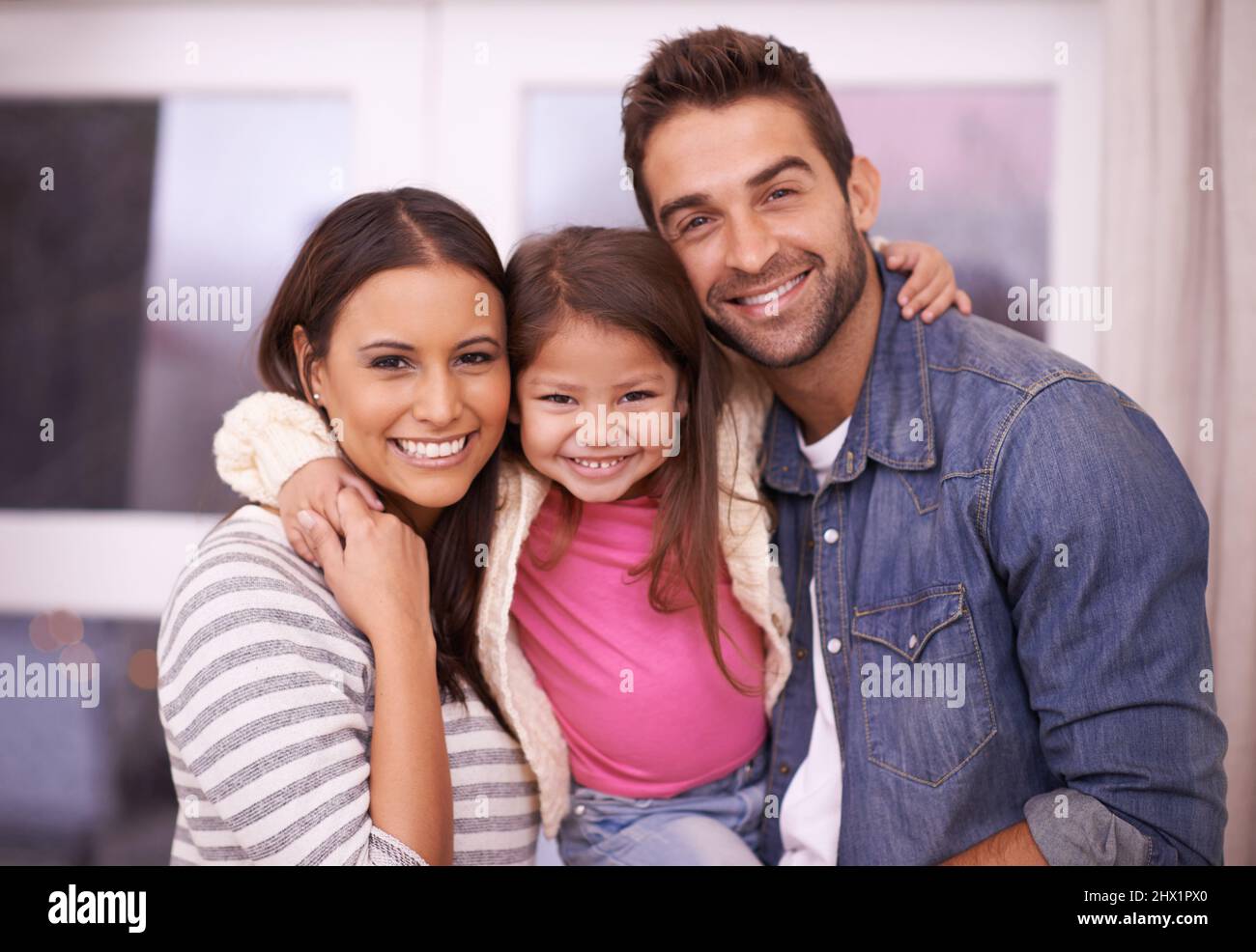 Theyre one happy family. Portrait of a happy young family sitting ...