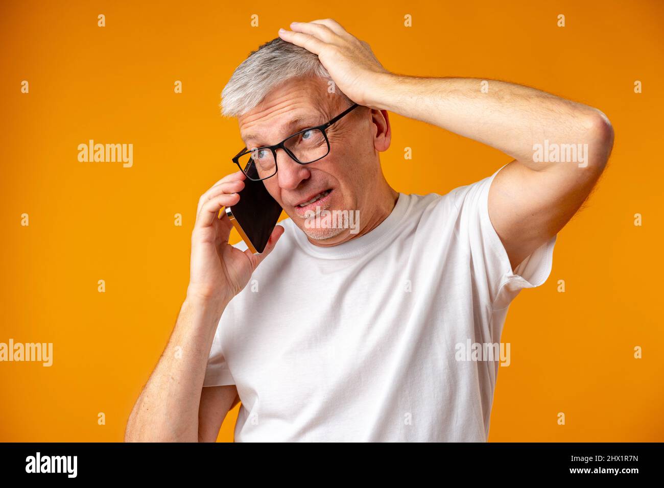 Concerned and troubled shocked senior man using smartphone Stock Photo ...