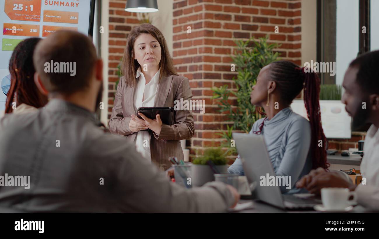 Close up of woman doing business presentation in boardroom, using ... Close up of woman doing business presentation in boardroom, using ...