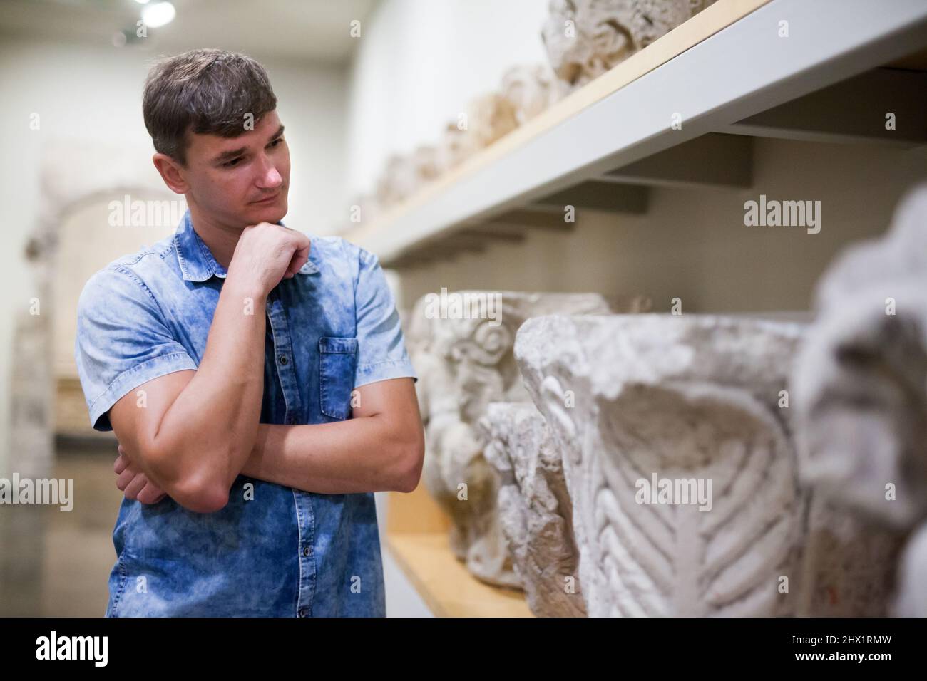 Man looking at stone architectural elements Stock Photo - Alamy