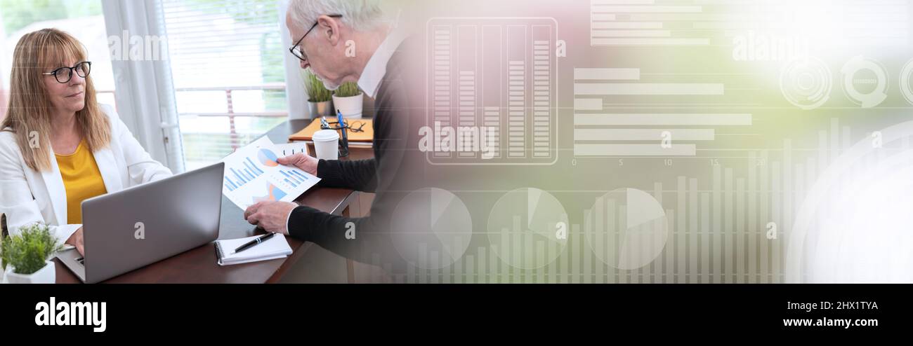 Two mature business people working together in office; panoramic banner ...