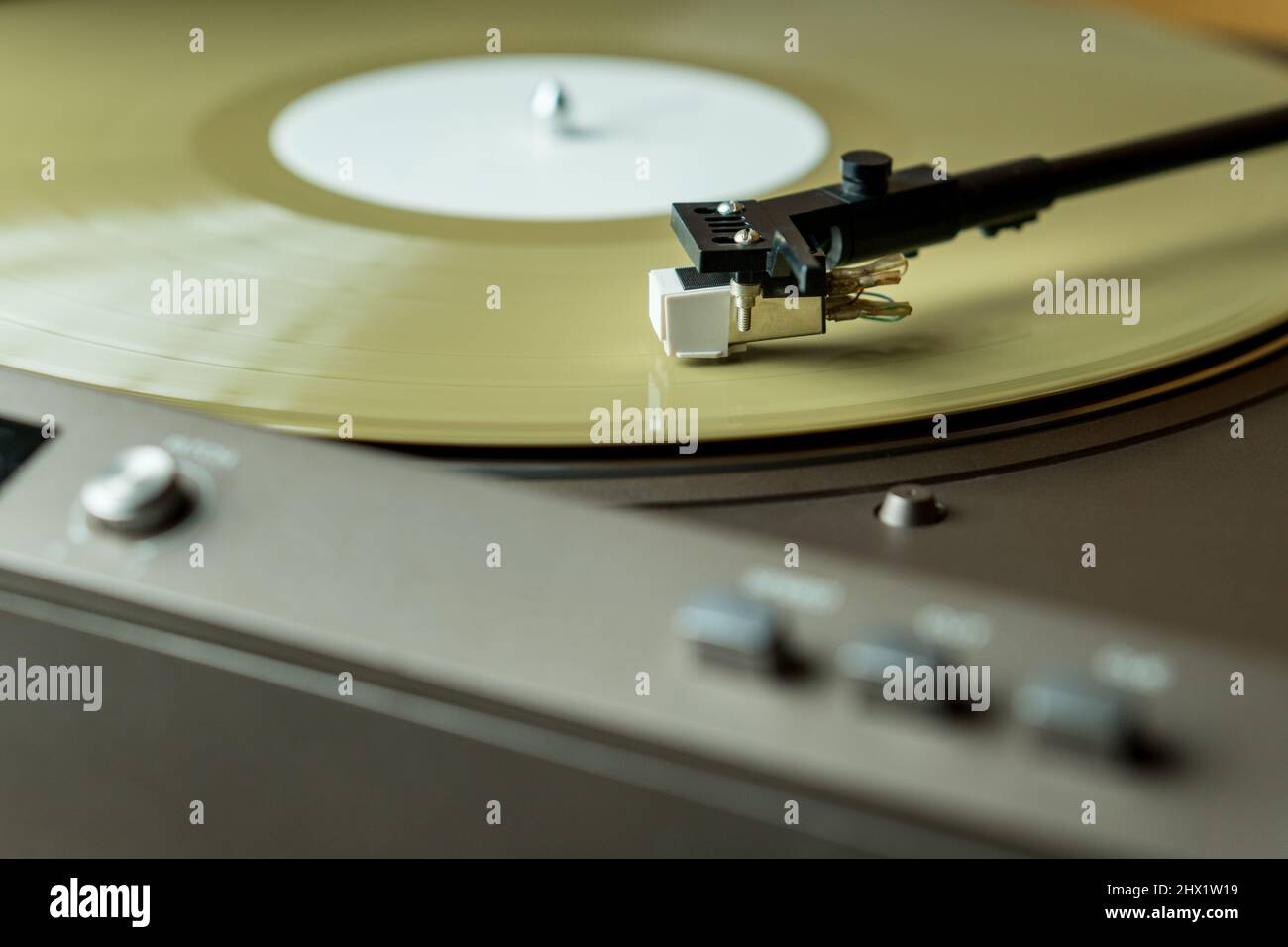 Closeup view of a tonearm and turntable playing color vinyl record ...