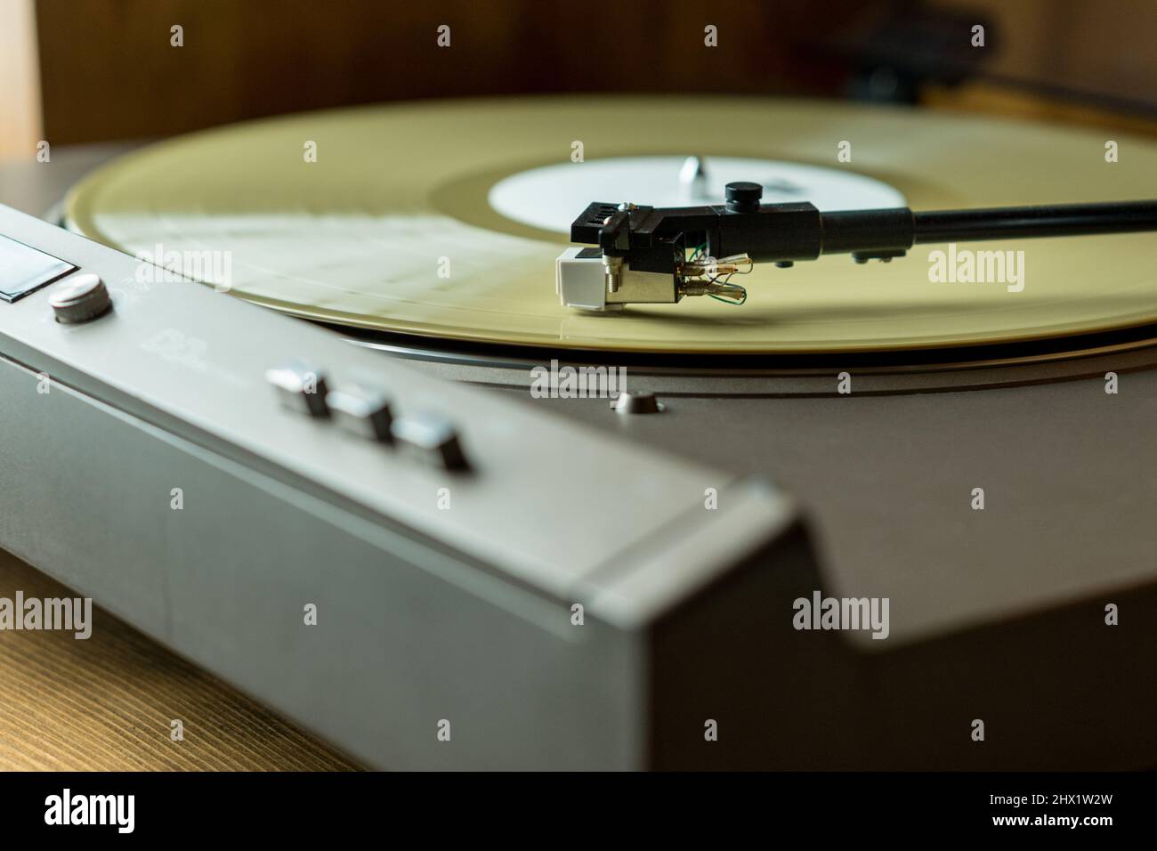 Closeup view of a tonearm and turntable playing color vinyl record ...