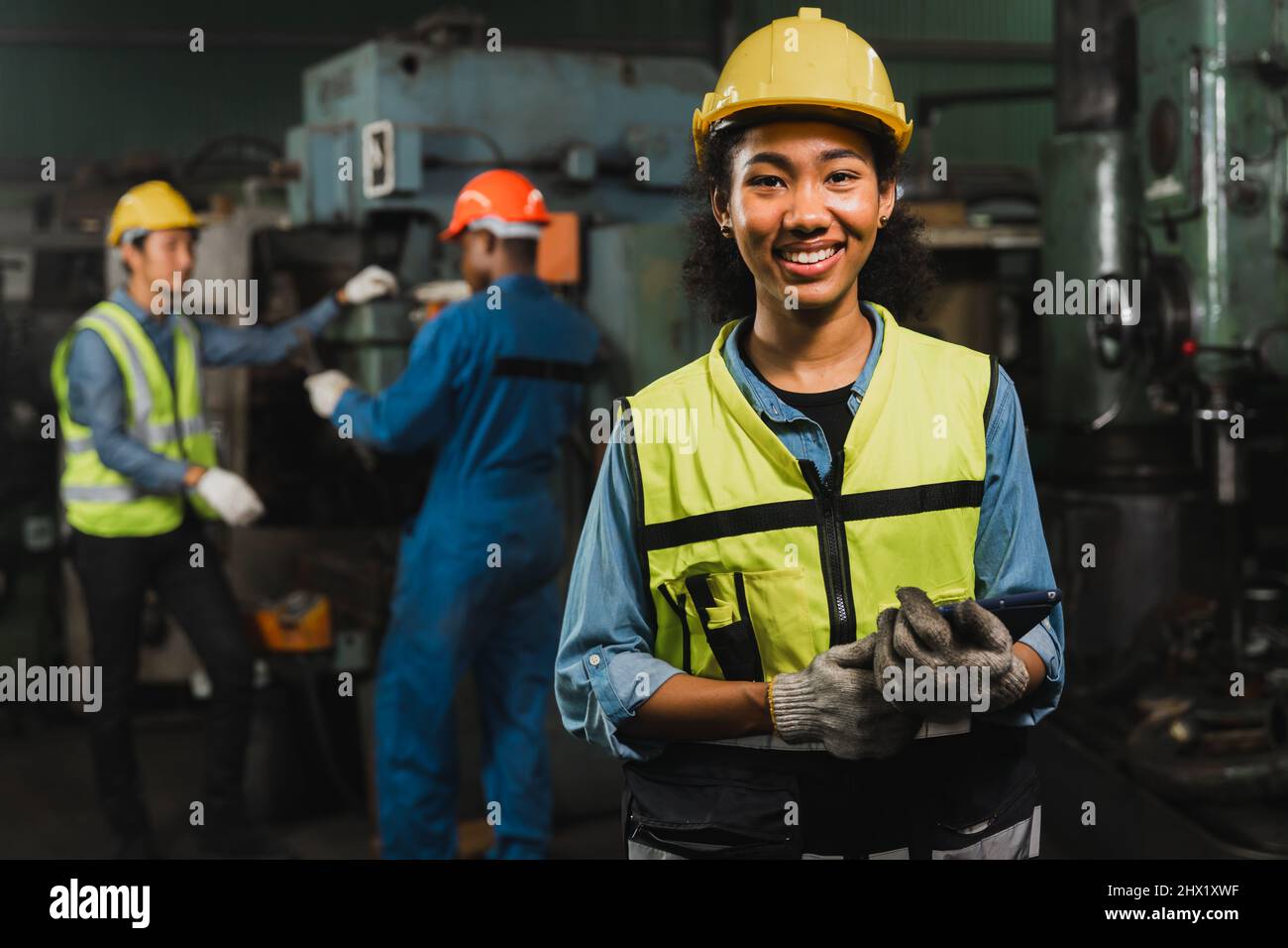 portrait of African engineering women holding tablet to check engine in ...