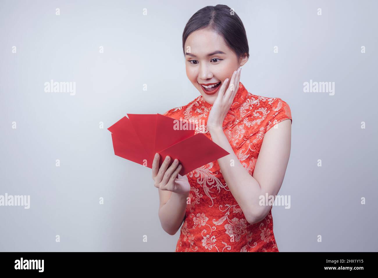 Asian woman in national dress of Chinese new year holding red ang pao ...