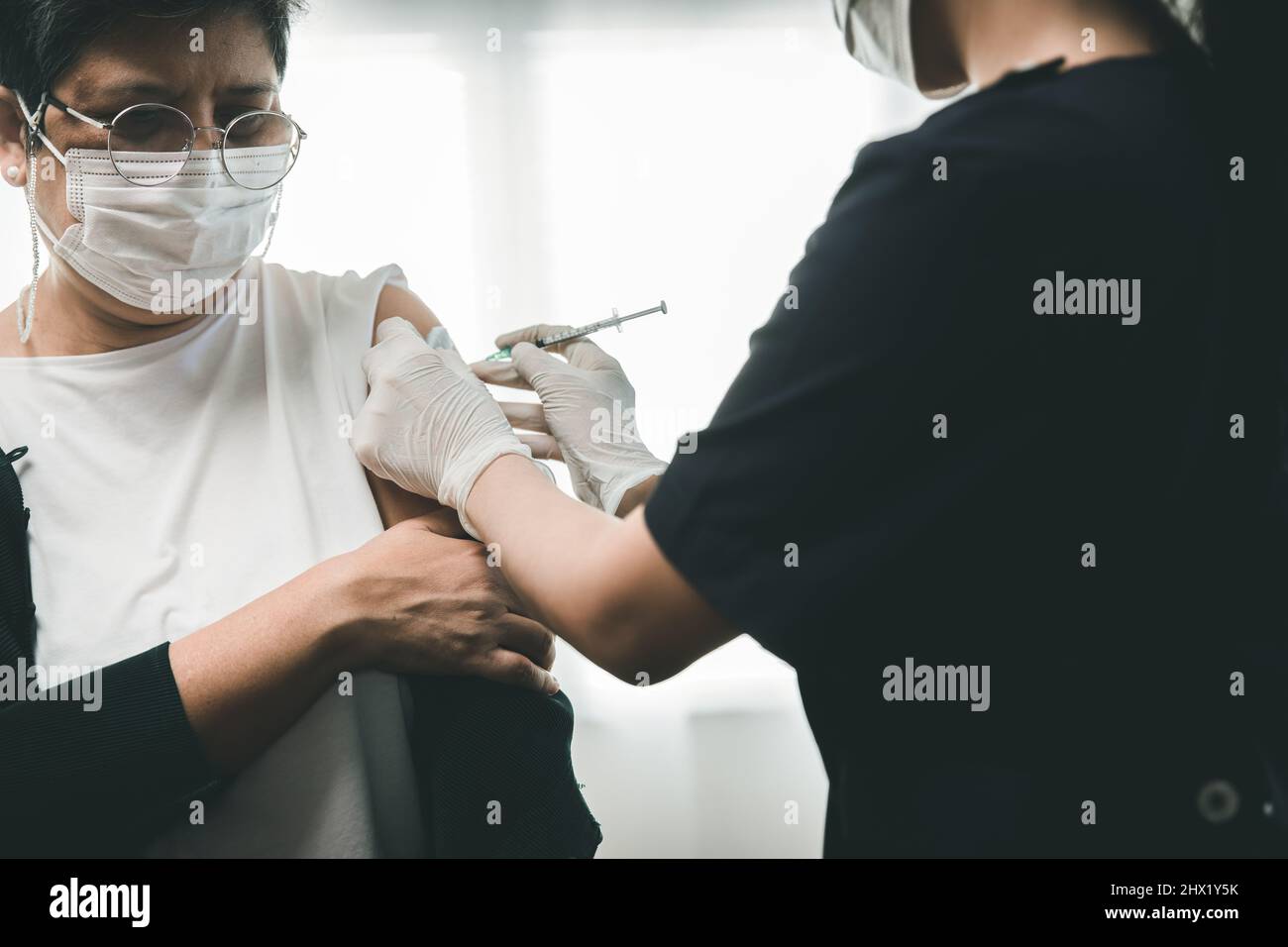 old Asian woman vaccinate with doctor giving shot to senior patient ...
