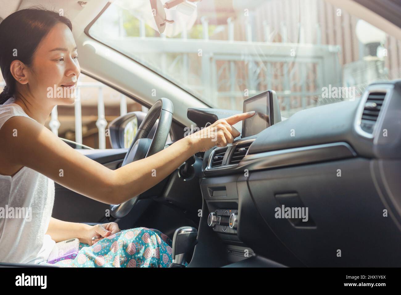 Woman driving car with hand touching navigation on monitor screen Stock ...