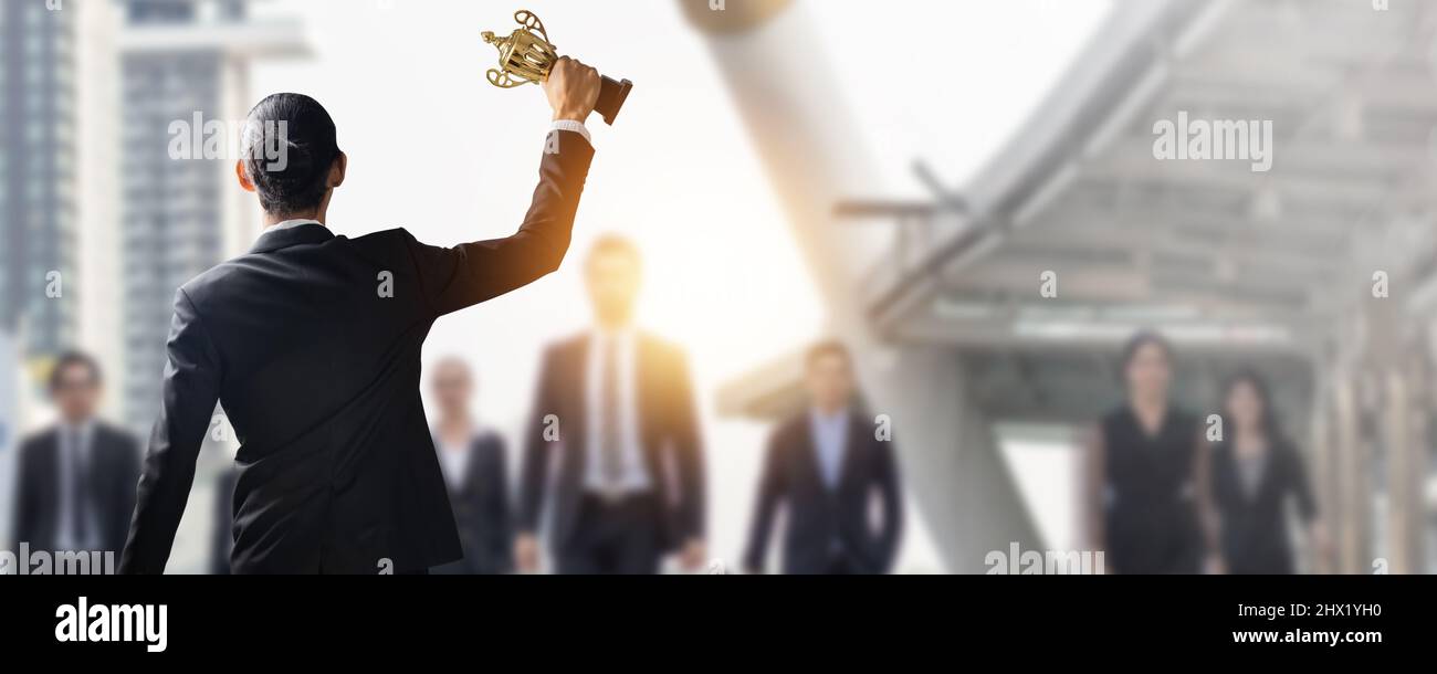 Hand holding up gold trophy hi-res stock photography and images - Alamy