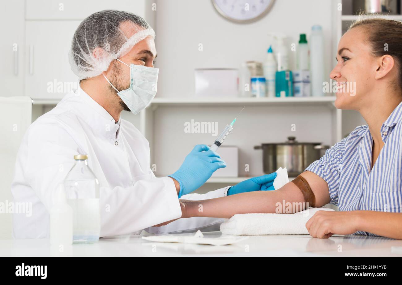 Male nurse injecting female patient Stock Photo - Alamy