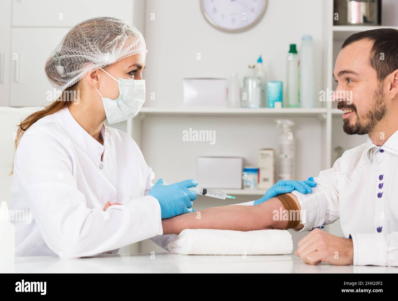 Female nurse injecting male patient Stock Photo - Alamy
