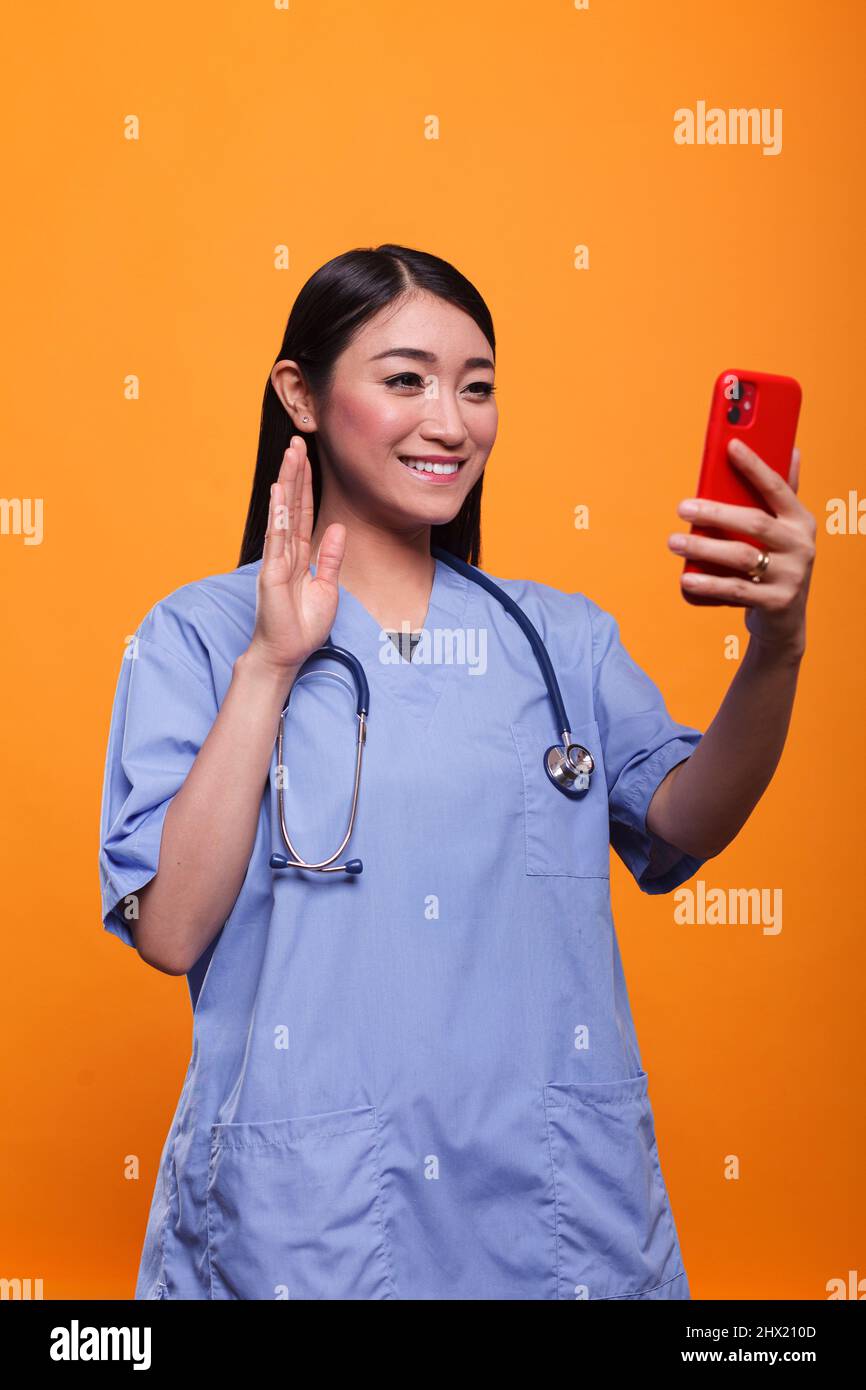 Smiling asian caregiver in remote telehealth videocall with patient ...