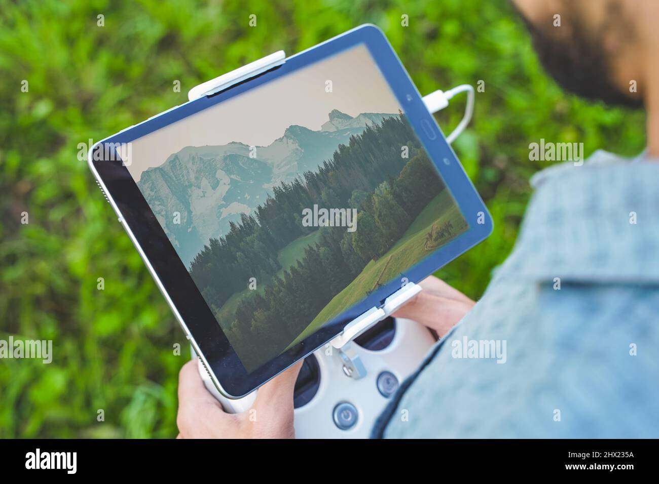 Young man flying drone on amazing mountain landscape. Man operating a ...