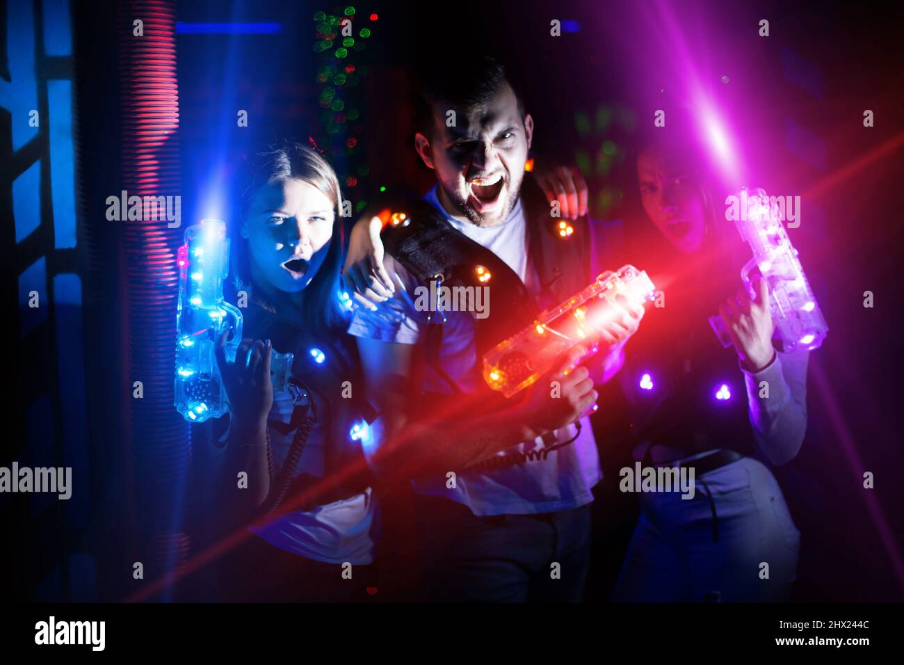 Young people with laser pistols in bright beams Stock Photo - Alamy