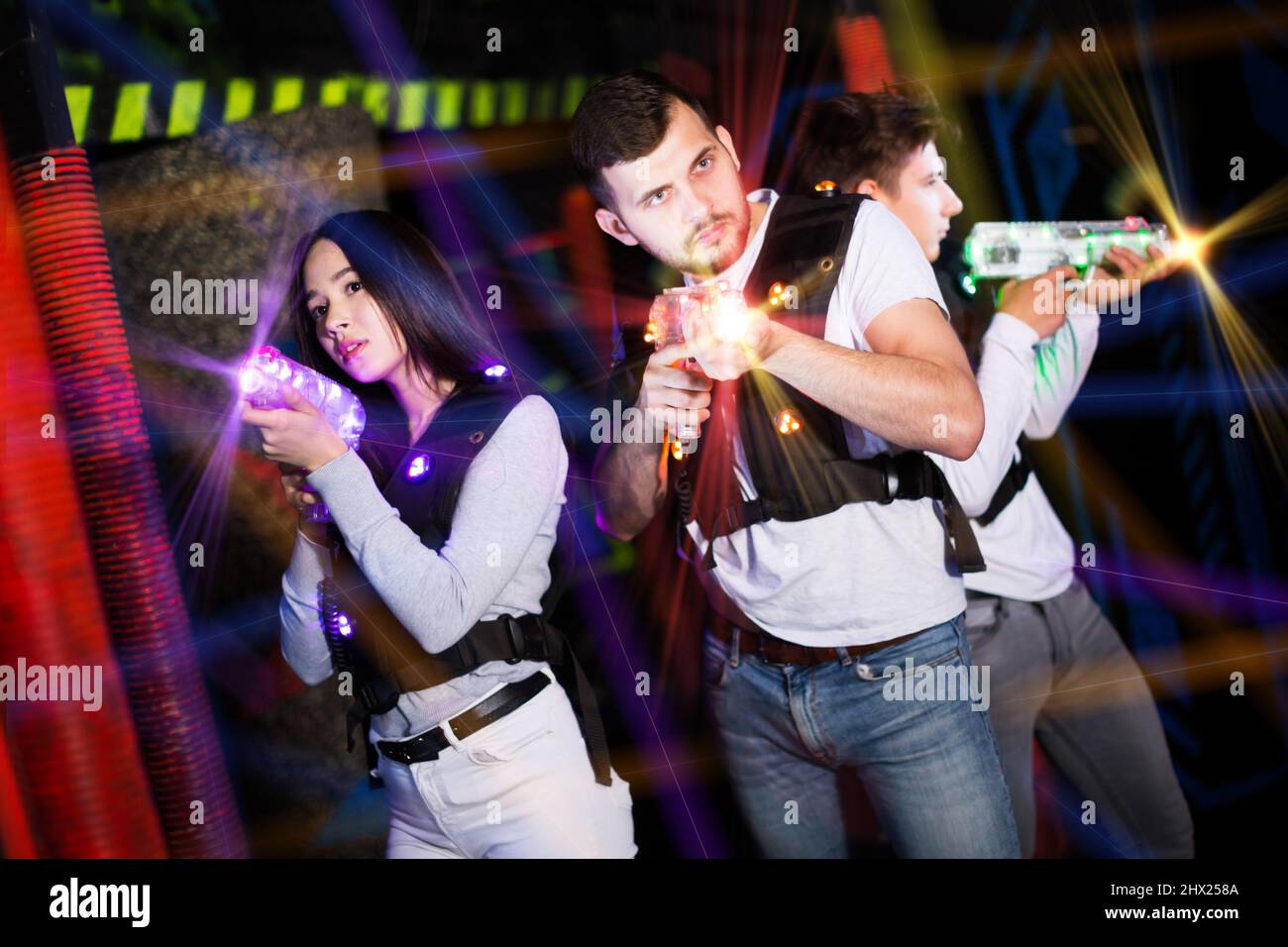Young people on lasertag in colorful beams Stock Photo - Alamy