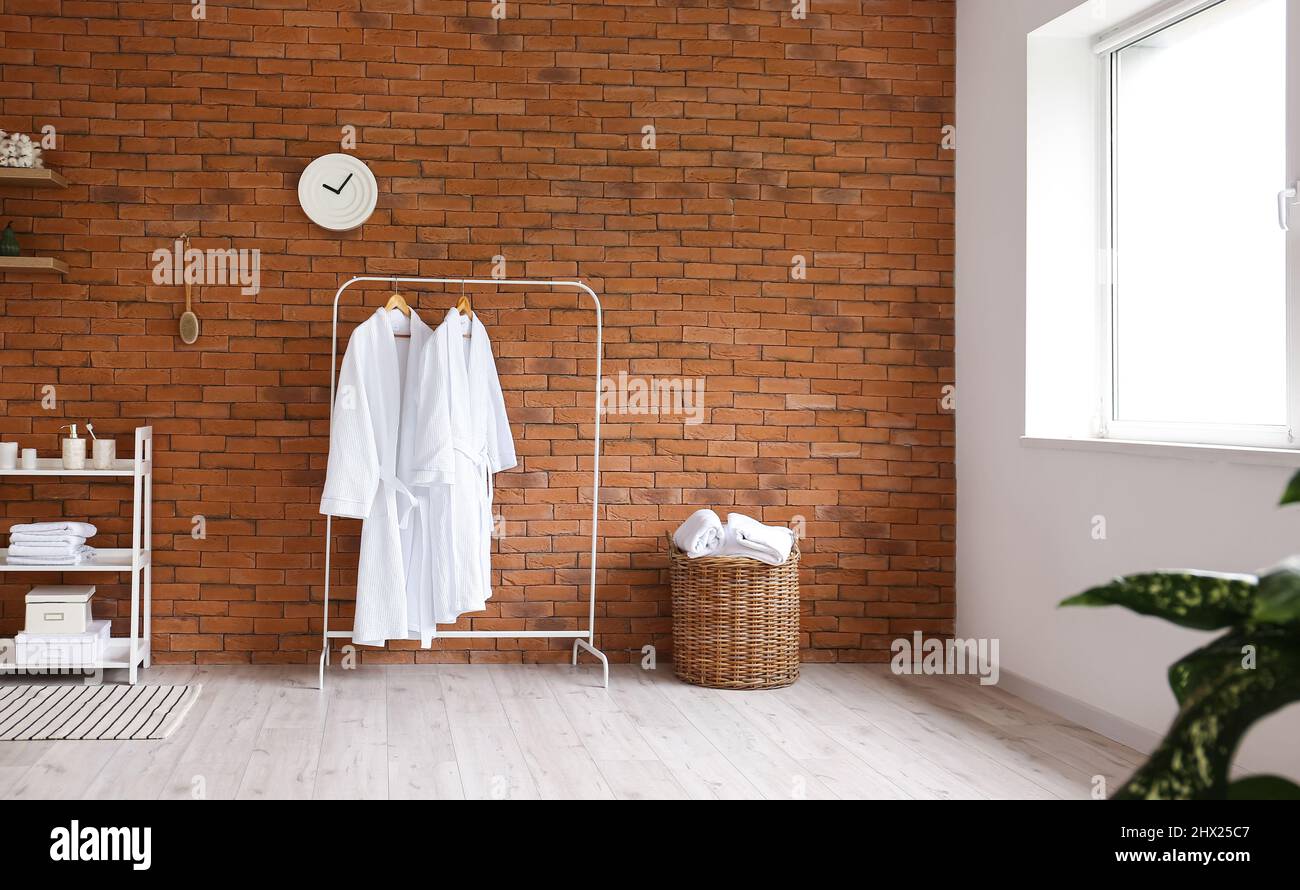 Interior of bathroom with shelving unit and rack with bathrobes Stock ...