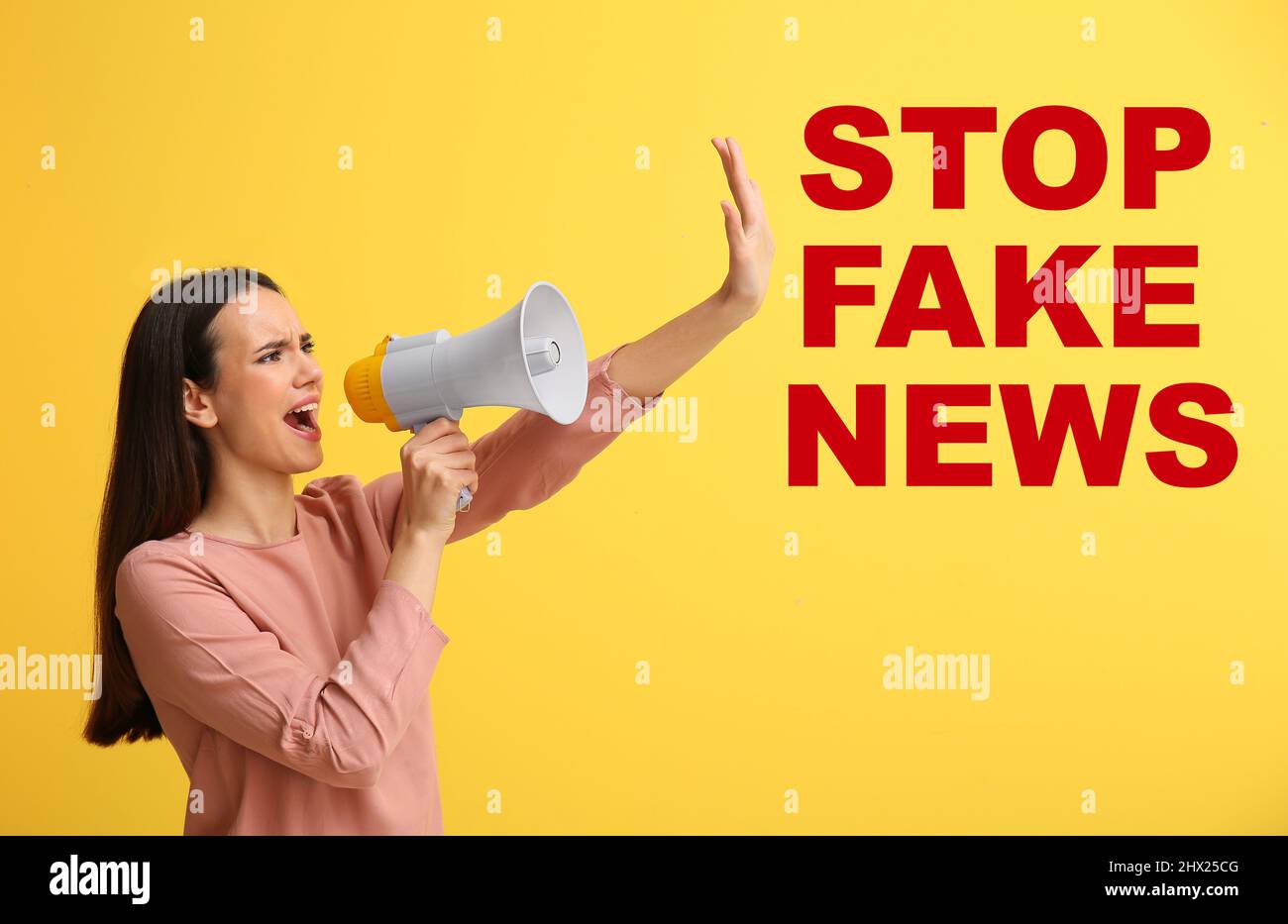 Screaming young woman with megaphone and text STOP FAKE NEWS on yellow ...