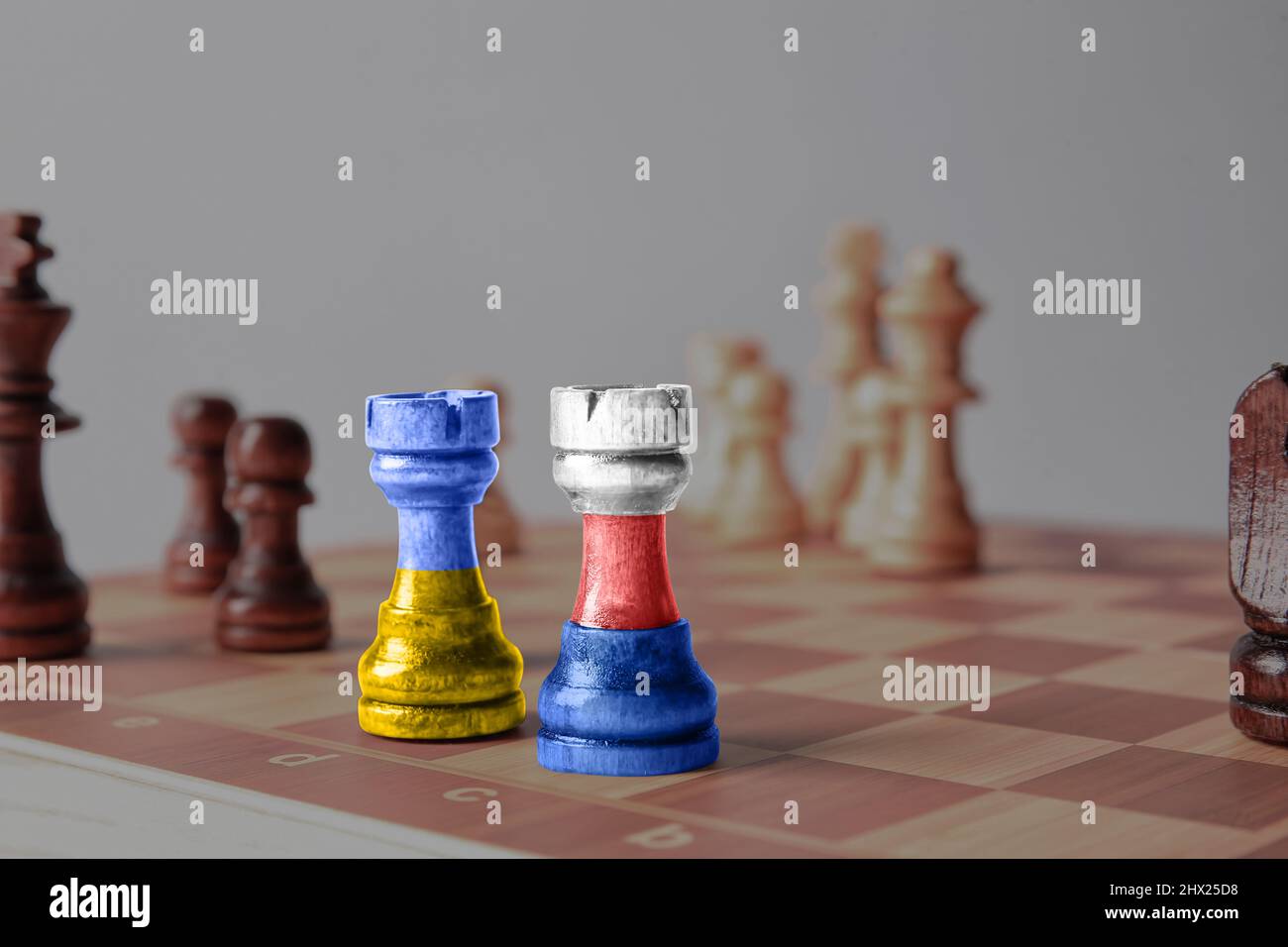 Game board with chess pieces in colors of Ukrainian and Russian flags ...