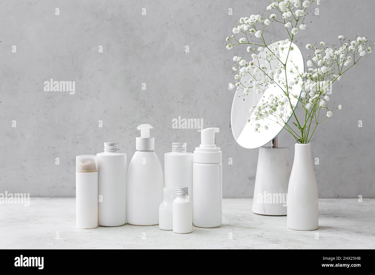 Set of cosmetic products, mirror and flowers on light background Stock ...