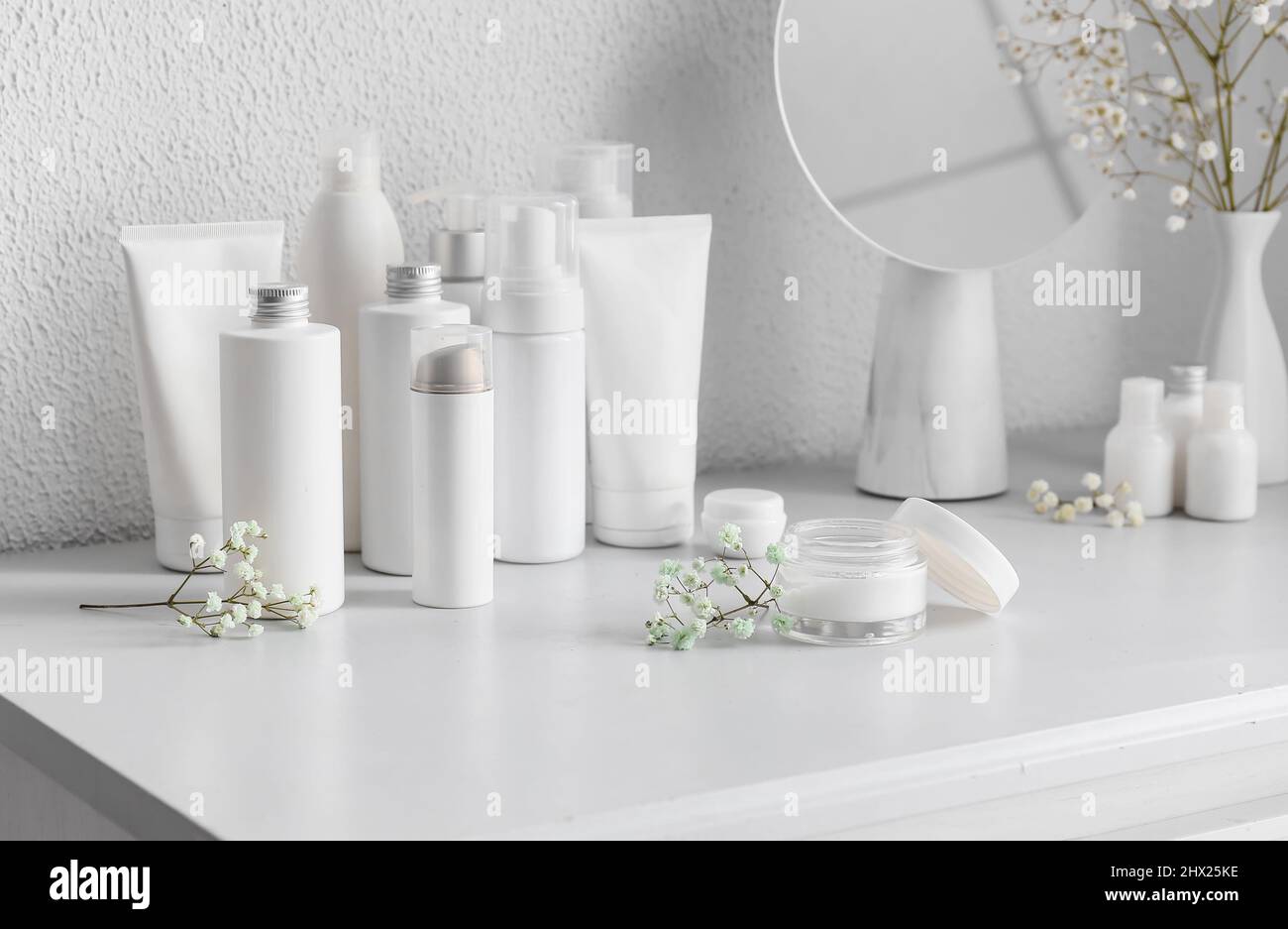 Different cosmetic products on light table Stock Photo - Alamy