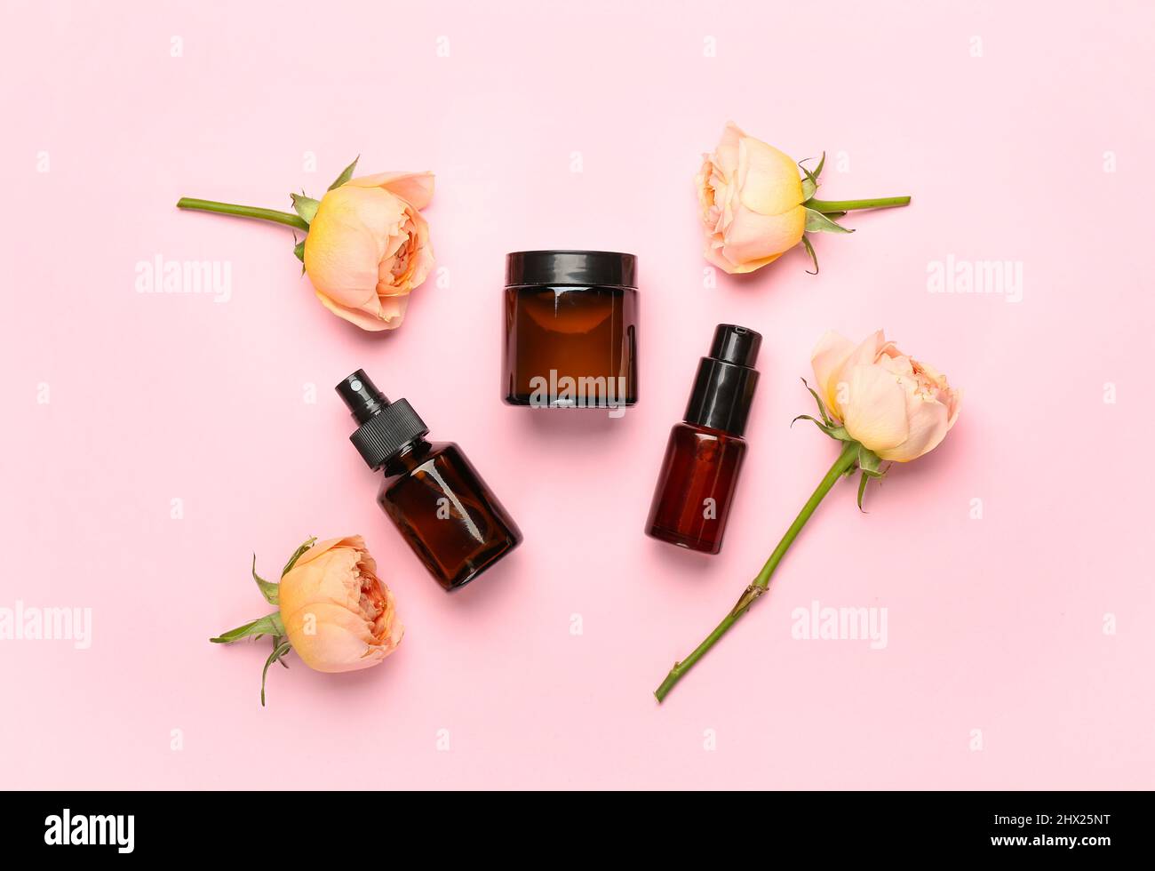 Cosmetic products and beautiful rose flowers on pink background Stock ...