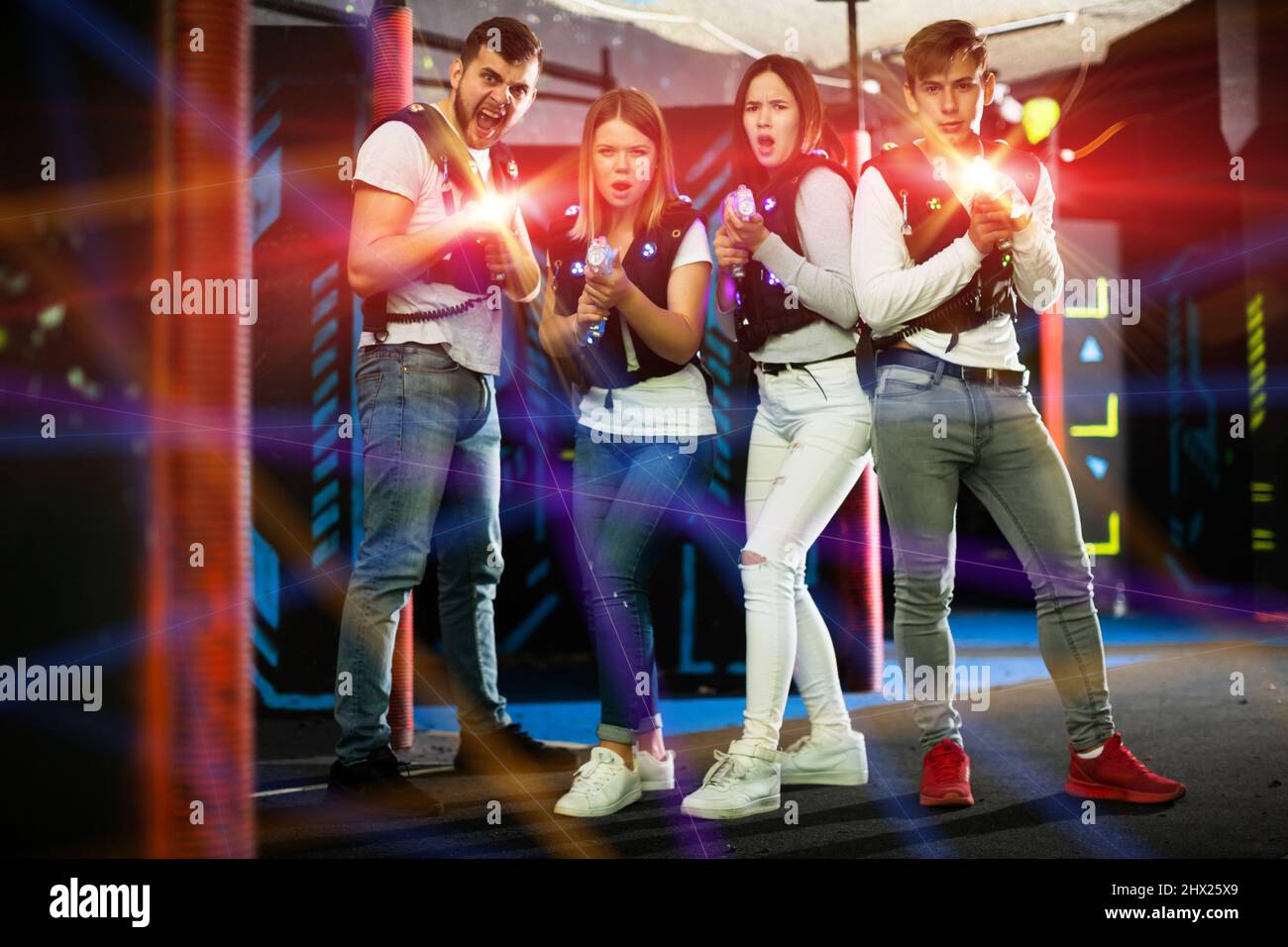 Friends with laser guns in colored beams Stock Photo - Alamy