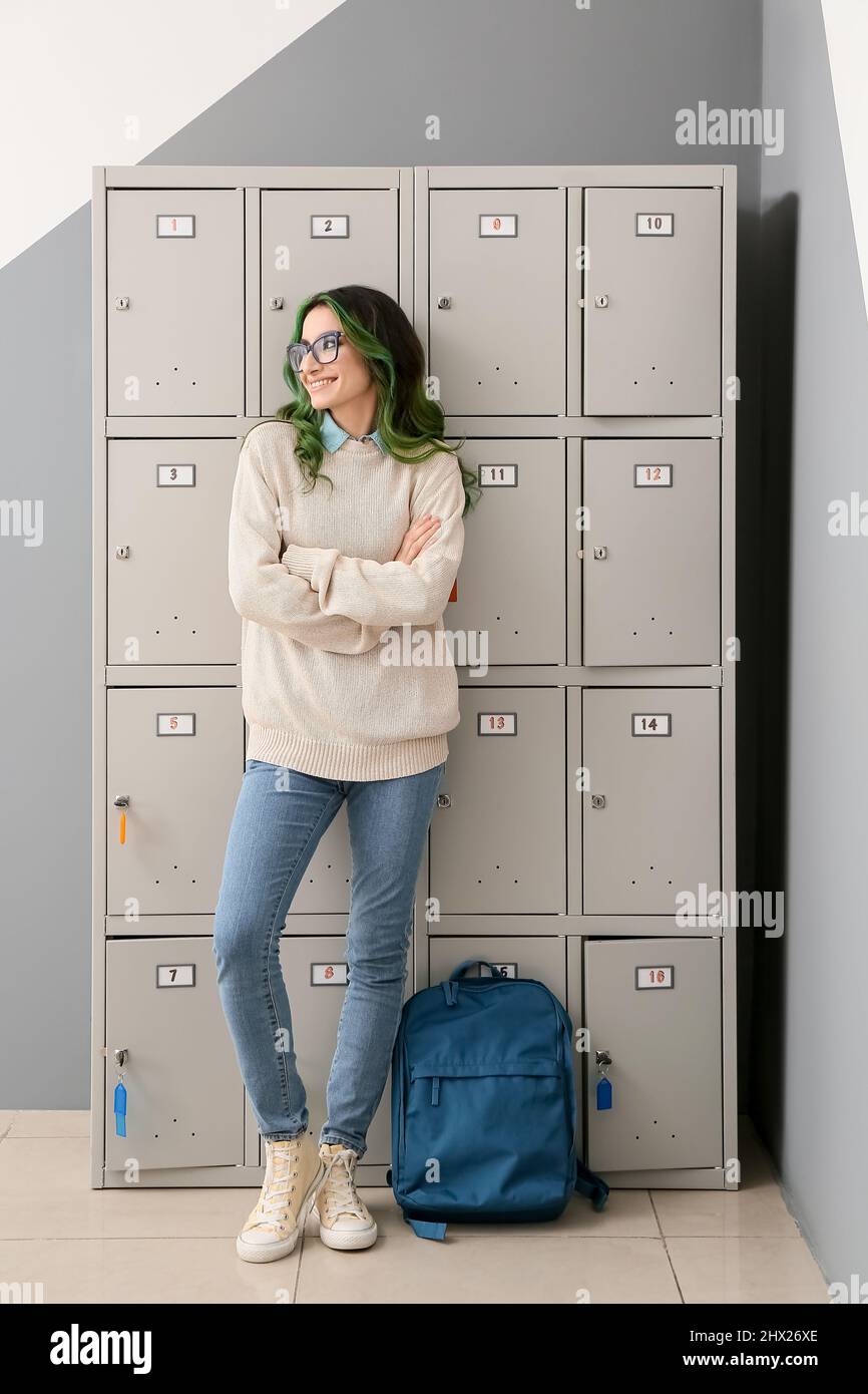 Beautiful female student near locker at the university Stock Photo - Alamy