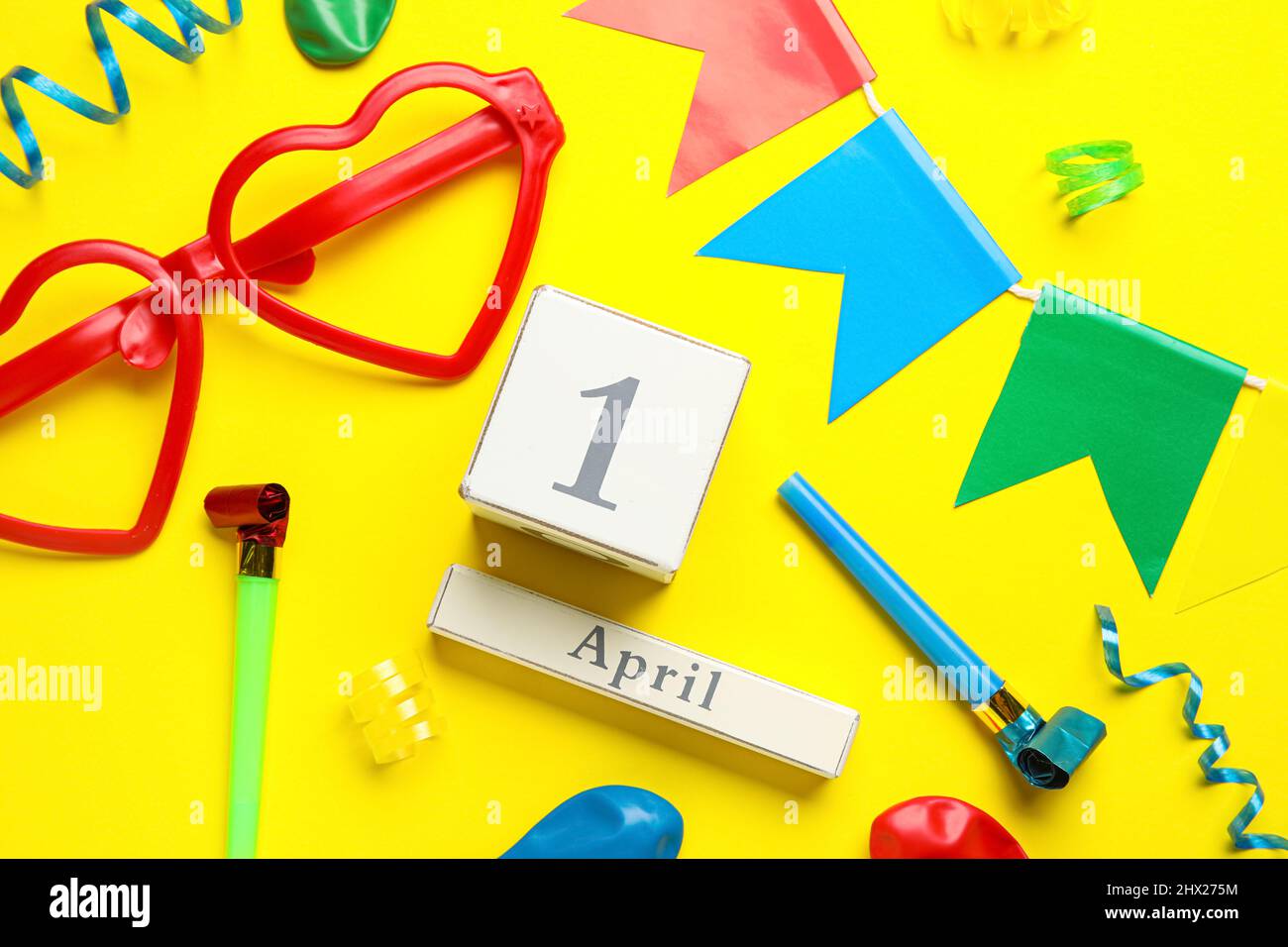 Calendar with date of April Fools Day and party decor on yellow ...