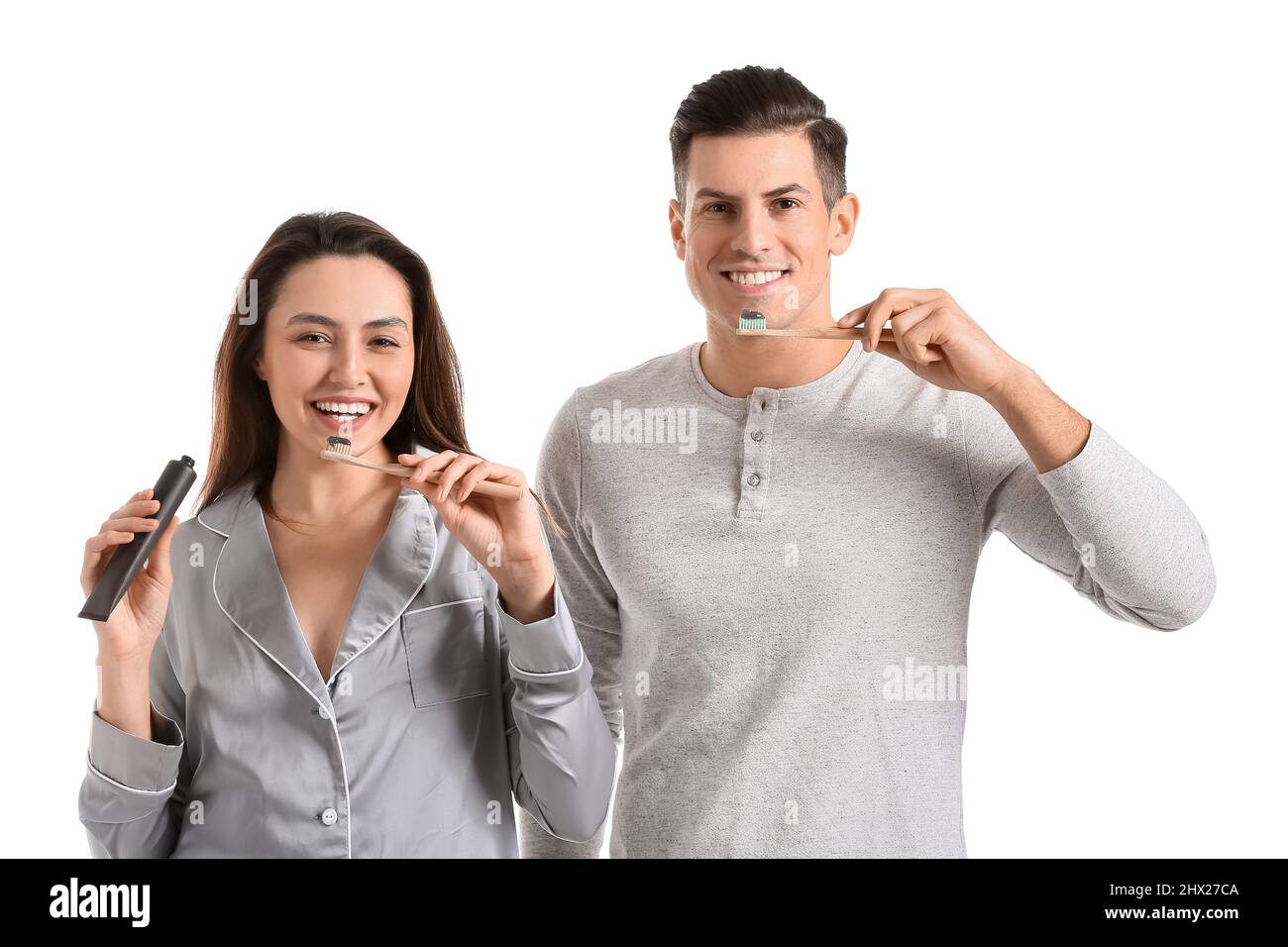 Young couple brushing teeth with activated charcoal tooth paste on ...
