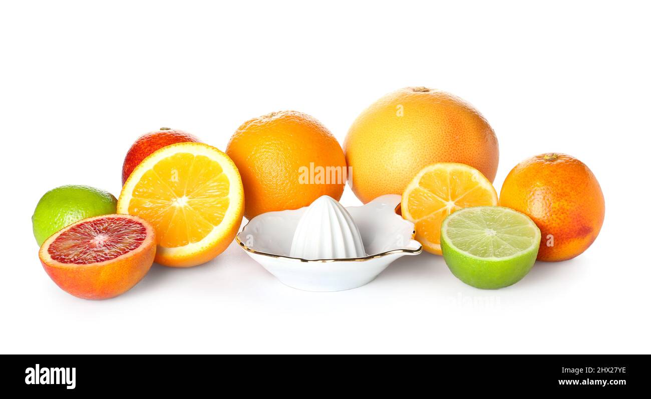 Ceramic juicer and citrus fruits on white background Stock Photo - Alamy