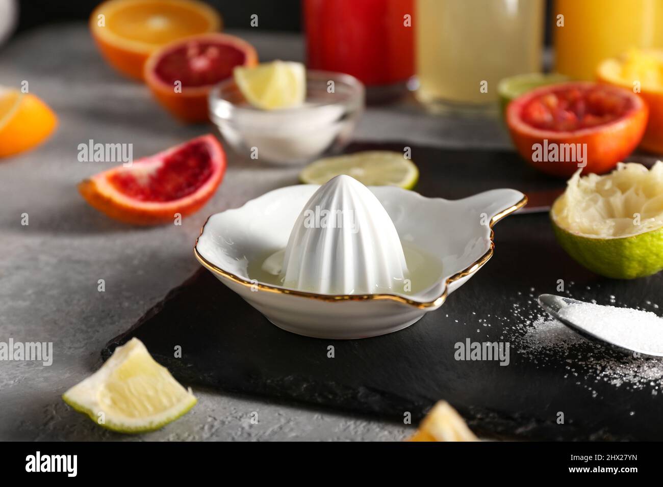 Ceramic juicer, sugar and citrus fruits on grey background Stock Photo ...