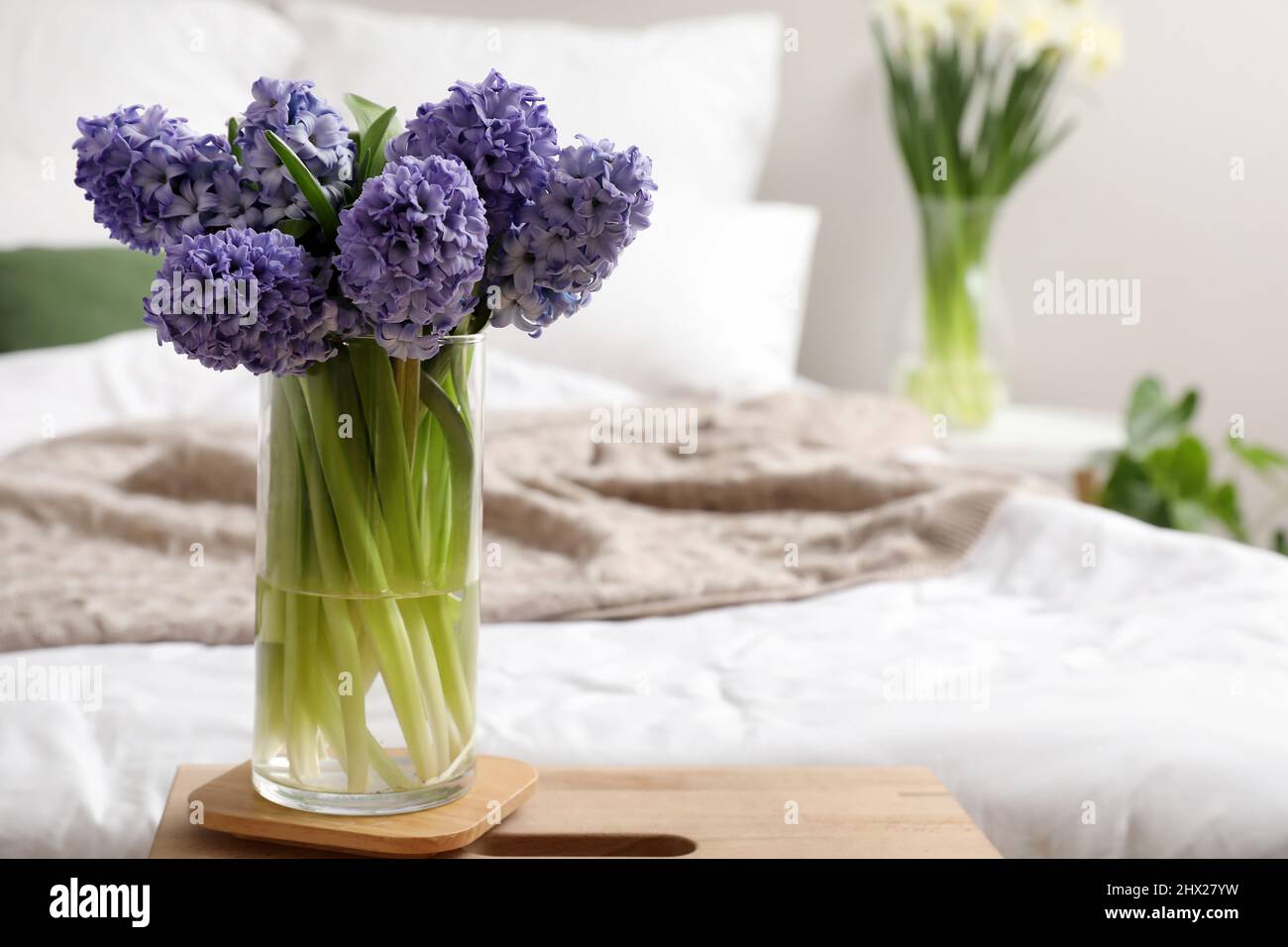 Vase with flowers on step stool in light bedroom Stock Photo - Alamy