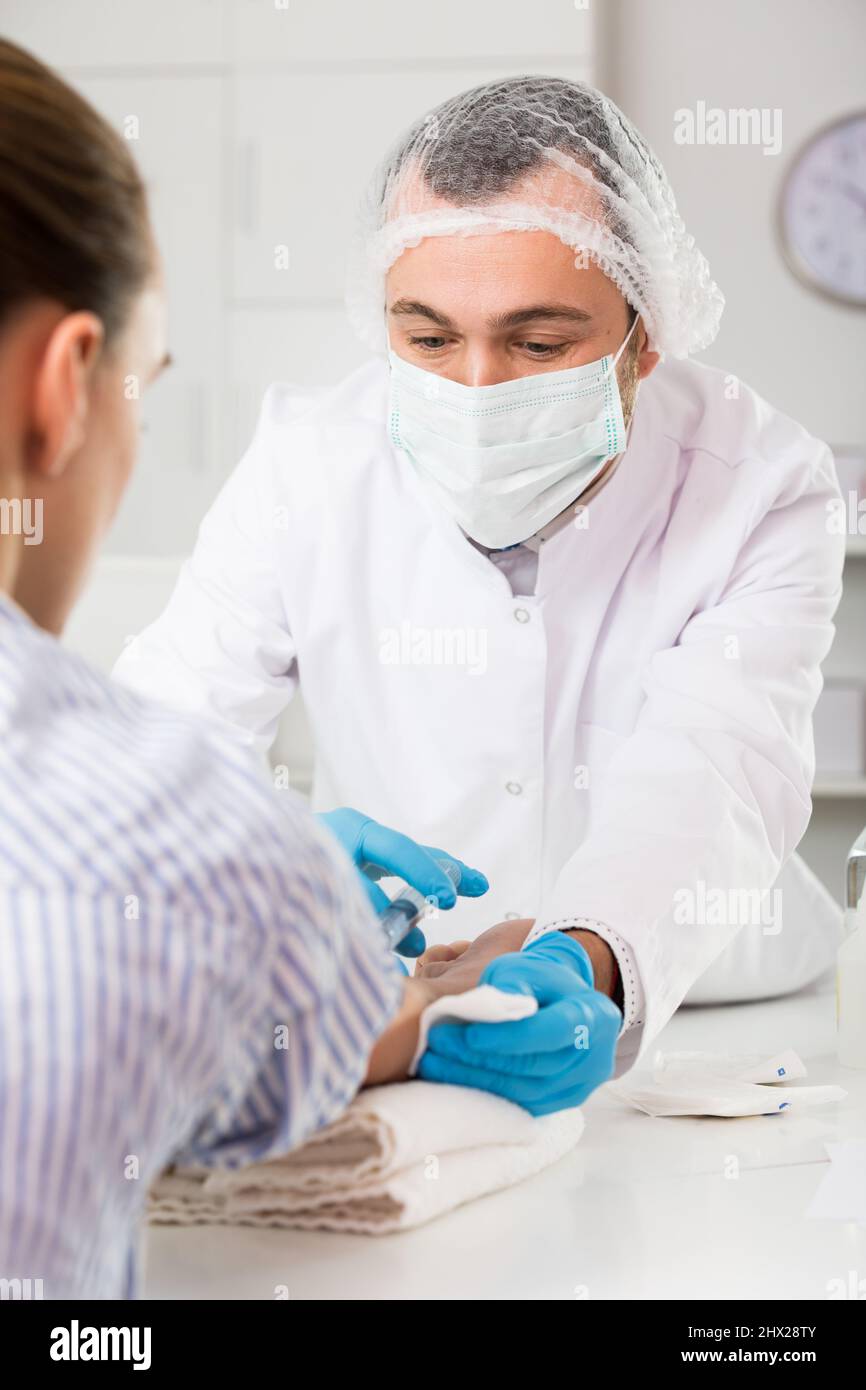Male nurse injecting female patient Stock Photo - Alamy