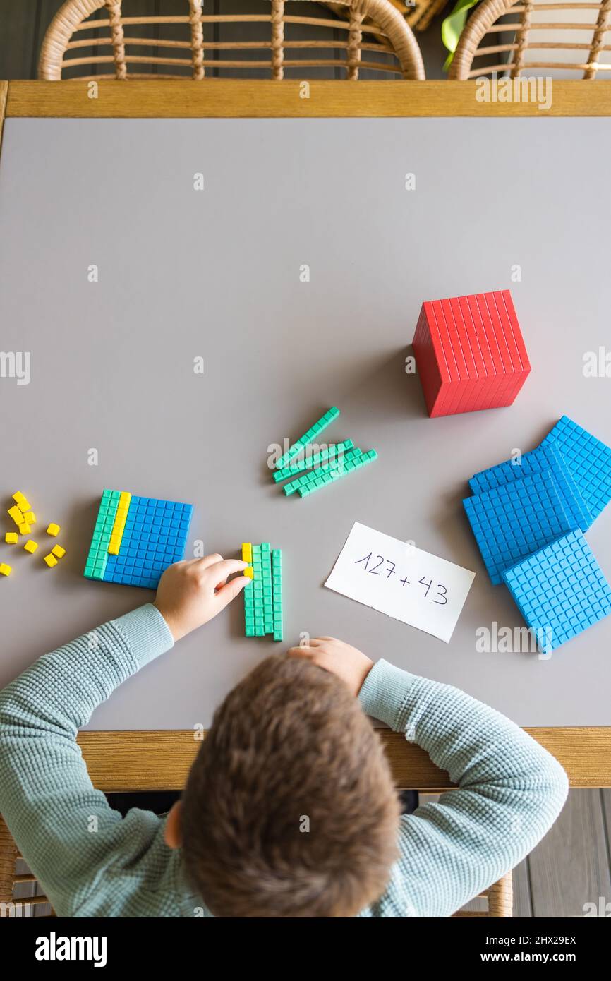 Little boy using the base 10 method to do addition at home Stock Photo ...