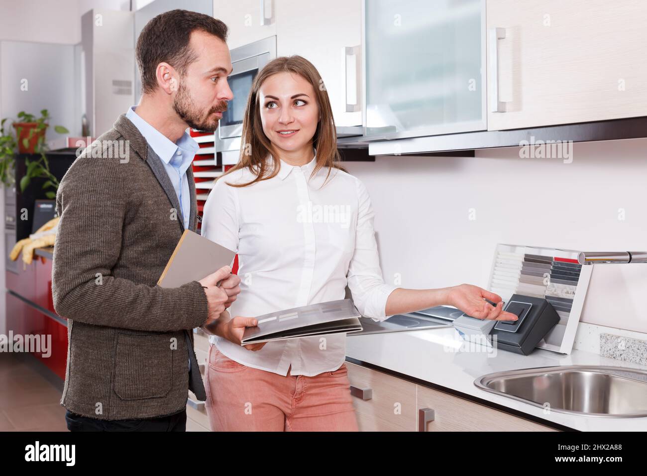Nice couple choosing new kitchen mixer tap Stock Photo - Alamy