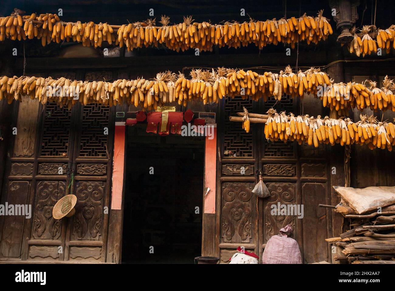 Exteriors of an old Chinese house, corn dry hanging on the lintel over ...