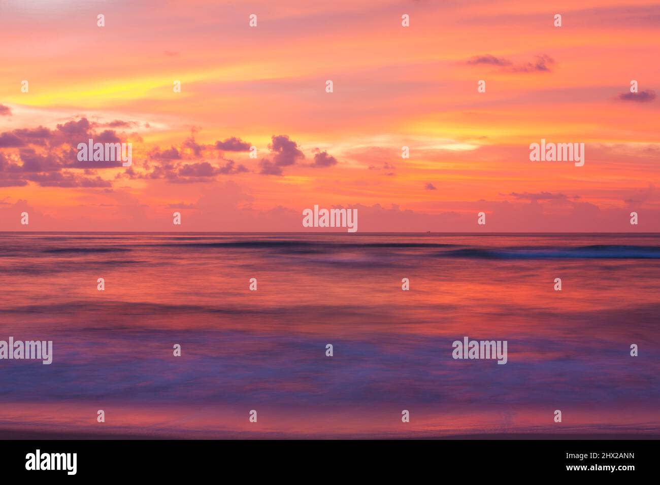 A tranquil seascape view during sunset, soft ocean waves crash on a ...