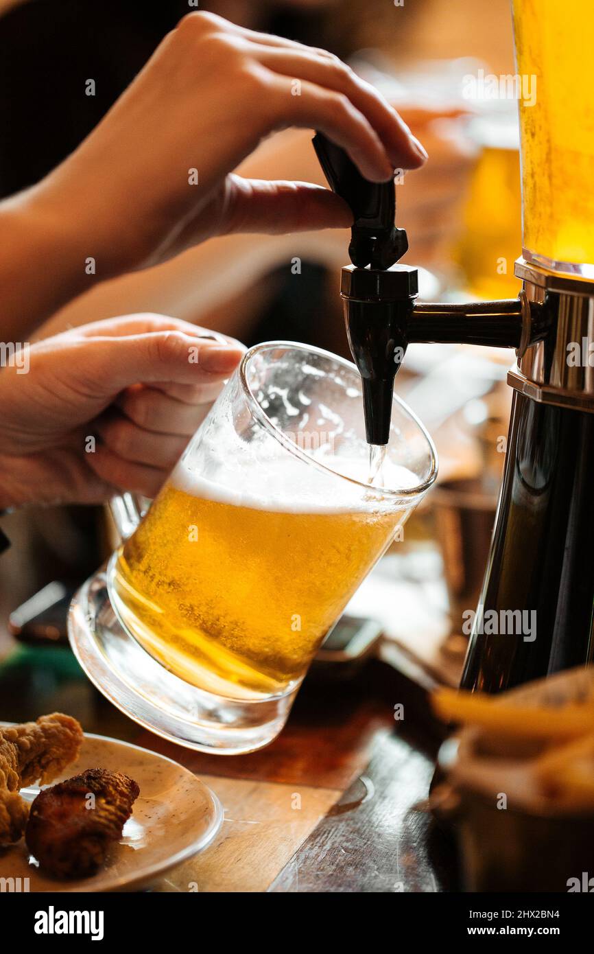 Hands pouring draught beer into a glass Stock Photo - Alamy