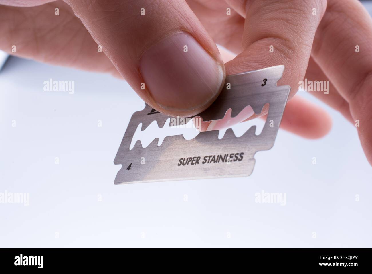 Hand holding sharp razor blade hi-res stock photography and images - Alamy