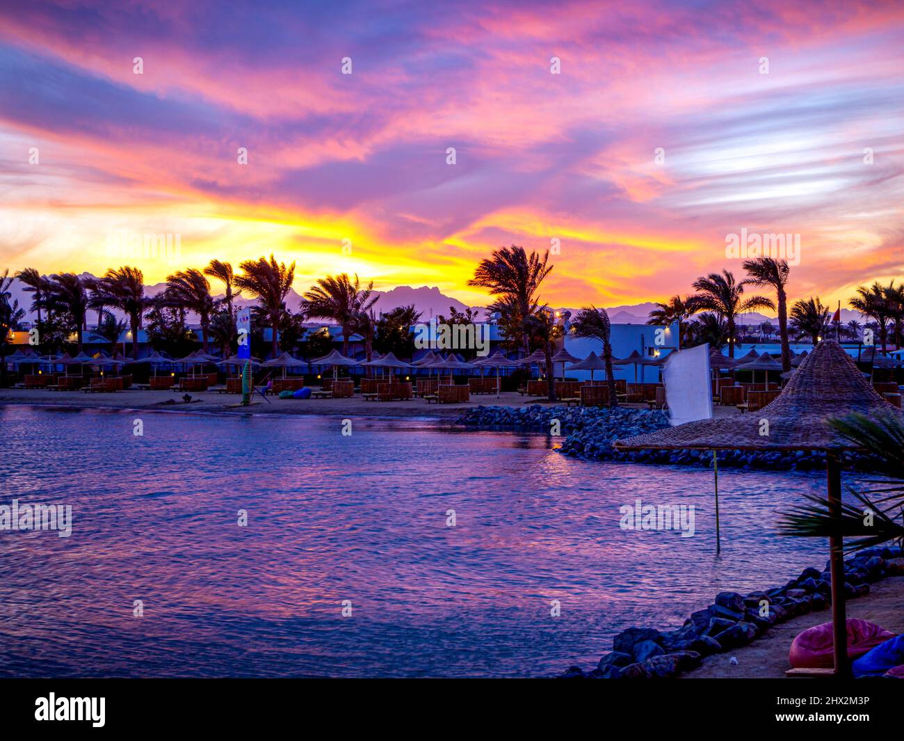 Sunset over the red sea palm tree silhuettes hotel in Hurgada, Egypt ...