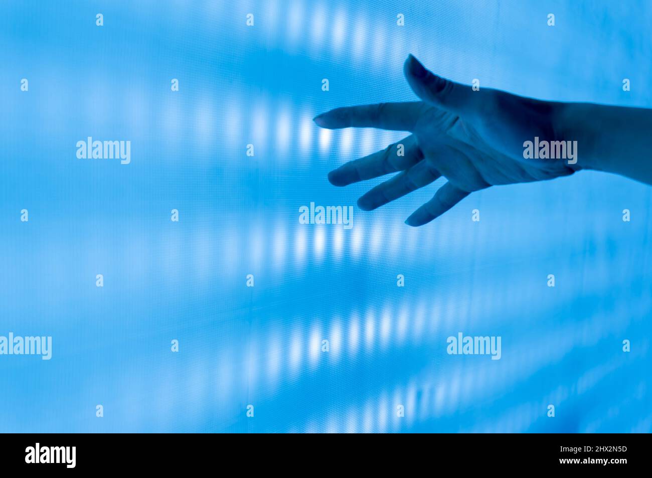 hand and led touch screen blue light science and technology background ...